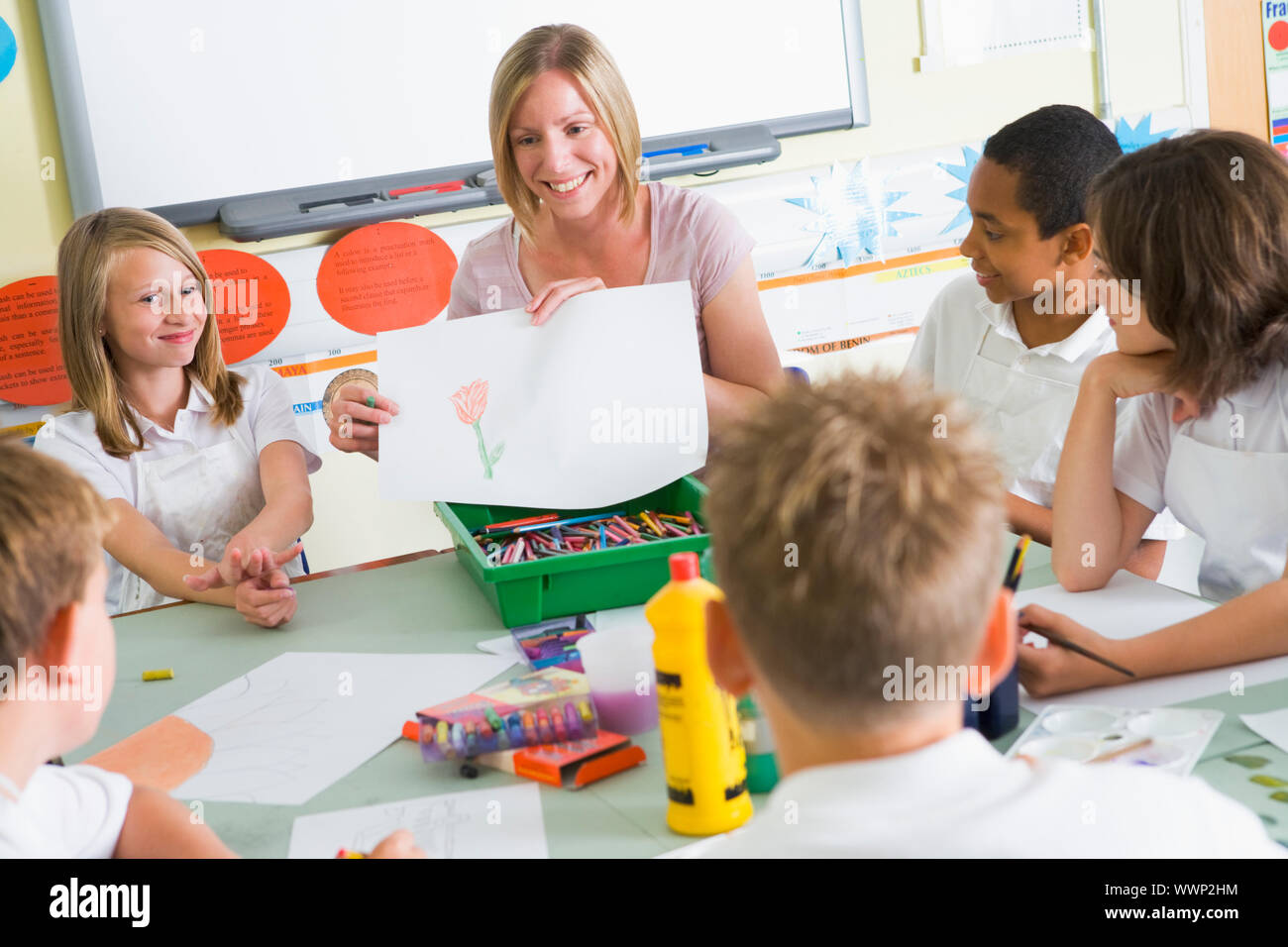 Students in art class with teacher showing a drawing Stock Photo - Alamy