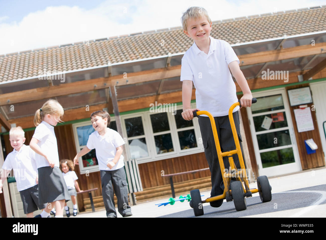 Students playing outdoors during recess one with a tricycle scooter ...