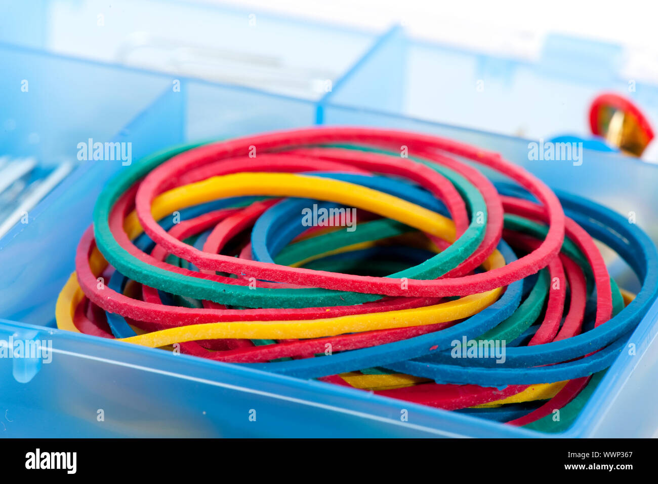 pile of Colorful rubber elastics in blue organizer Stock Photo - Alamy
