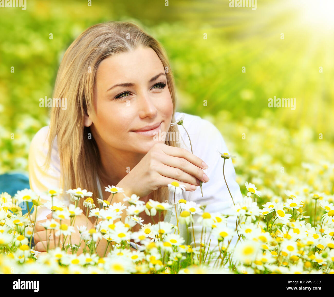 Beautiful female laying on the flower field Stock Photo - Alamy
