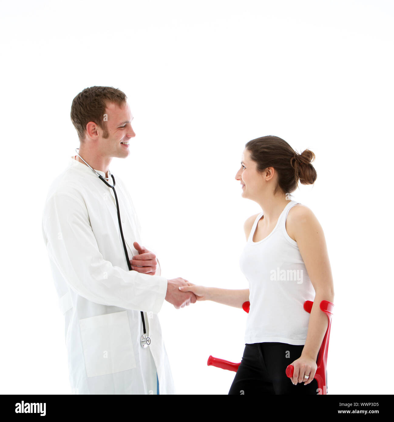 Smiling, kind doctor shaking hands with his female patient Stock Photo ...