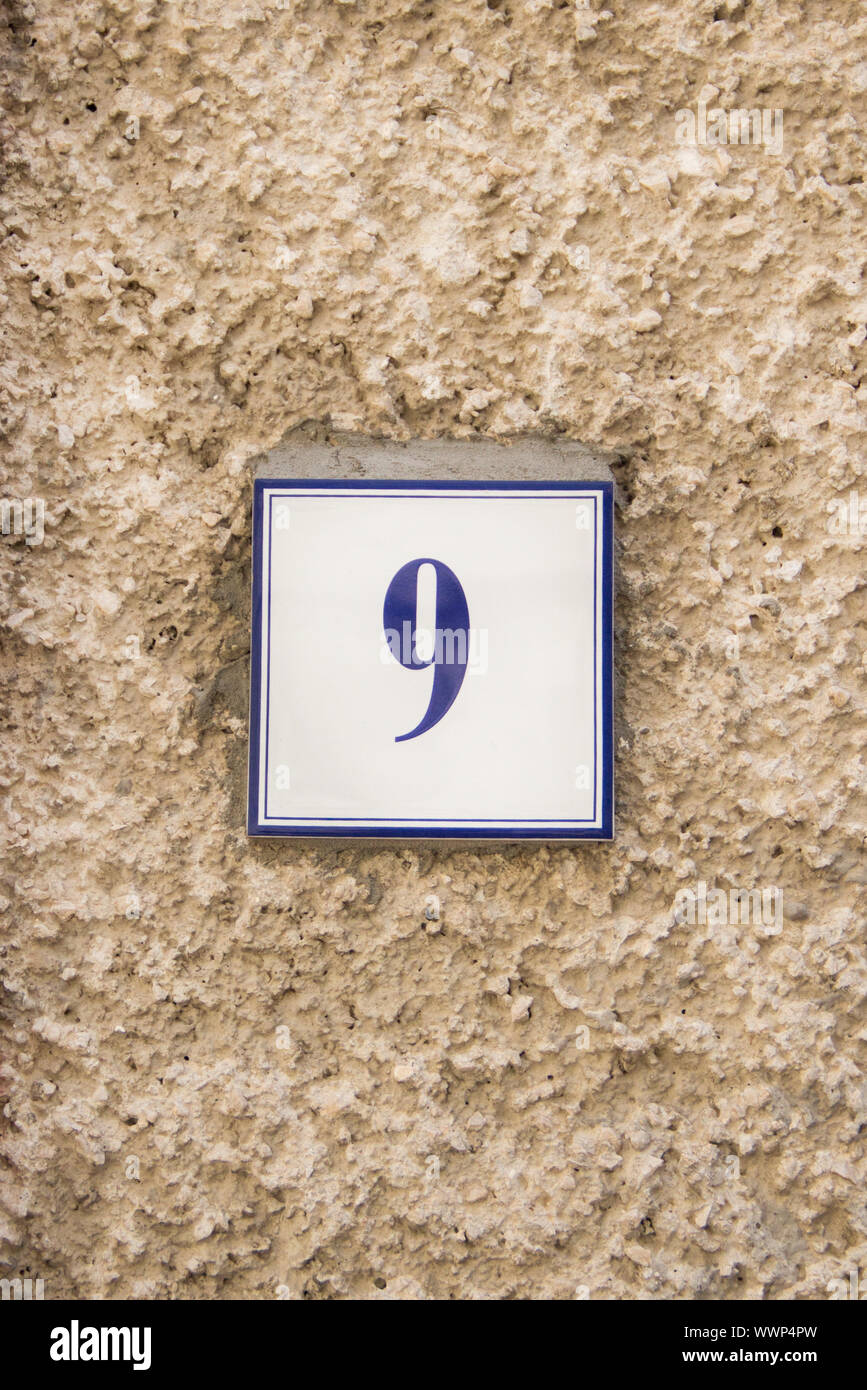 Ceramic number nine on the grey stone wall Stock Photo - Alamy