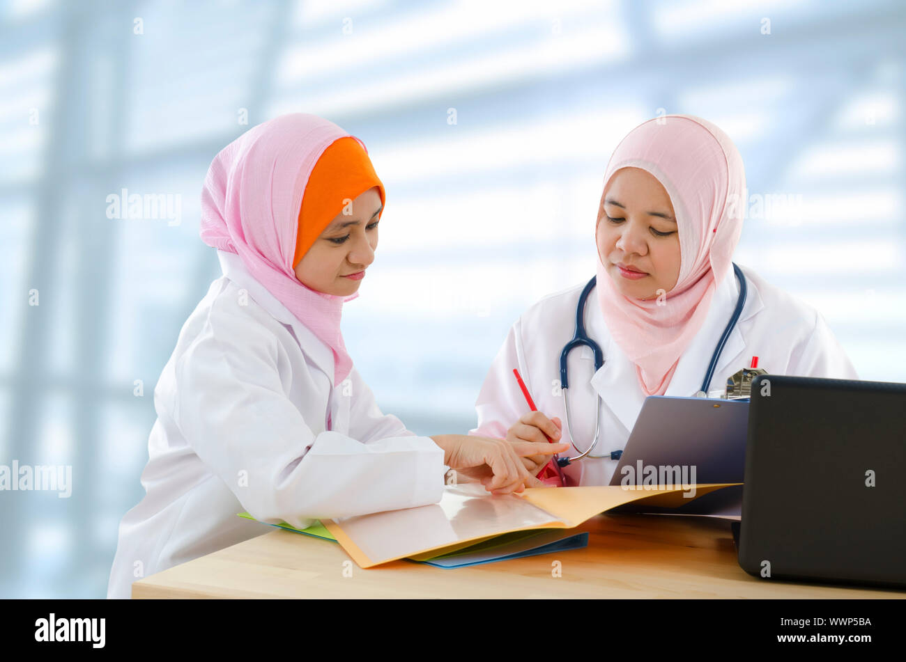 Two Muslim female doctor discussing patient report Stock Photo - Alamy