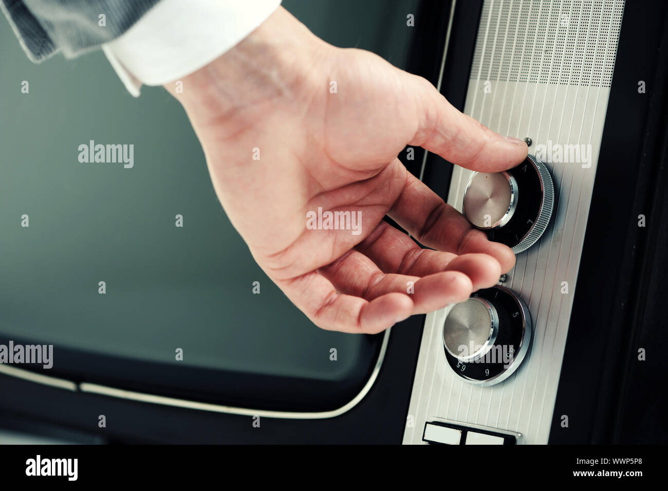 Man turning channel knob on retro television Stock Photo - Alamy