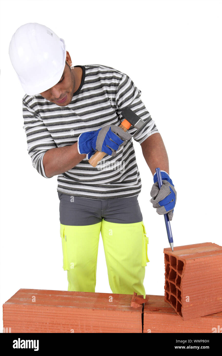 Worker using a hammer and chisel Stock Photo - Alamy