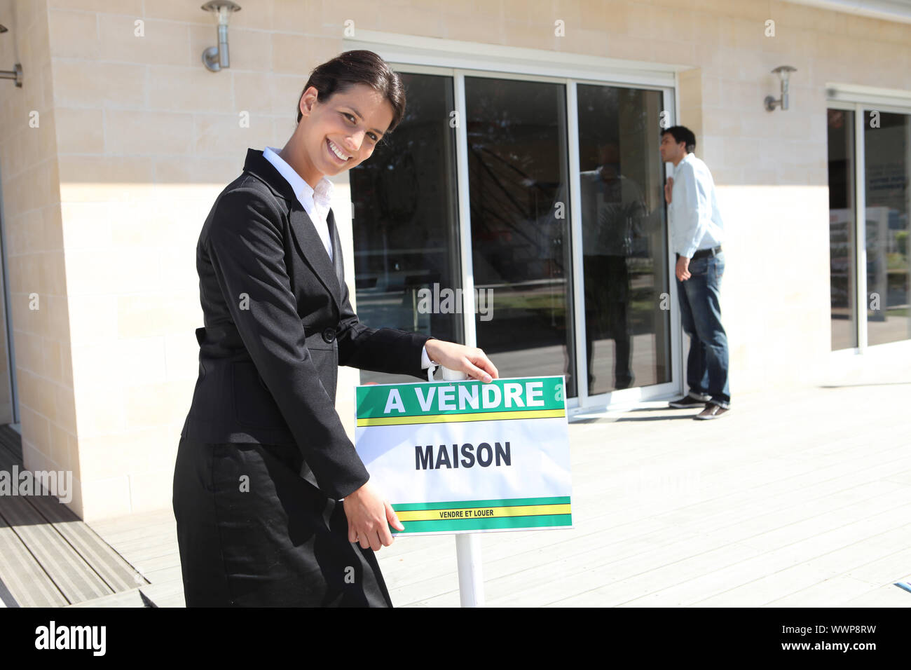 Estate agent with a French for sale sign Stock Photo - Alamy