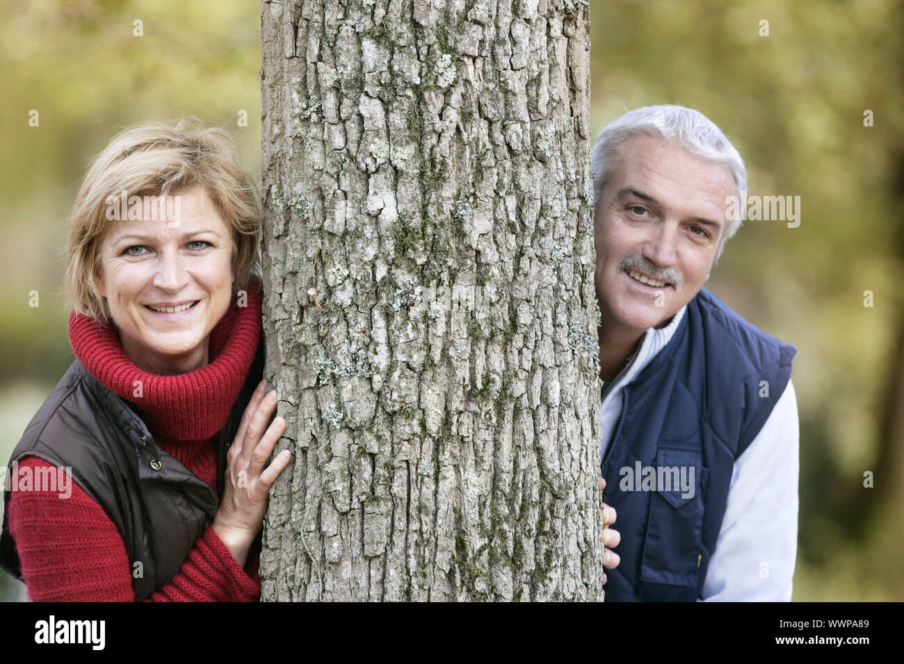 Man peeking behind tree hi-res stock photography and images - Alamy