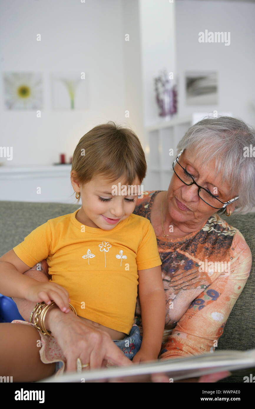 Young child reading with grandma Stock Photo - Alamy
