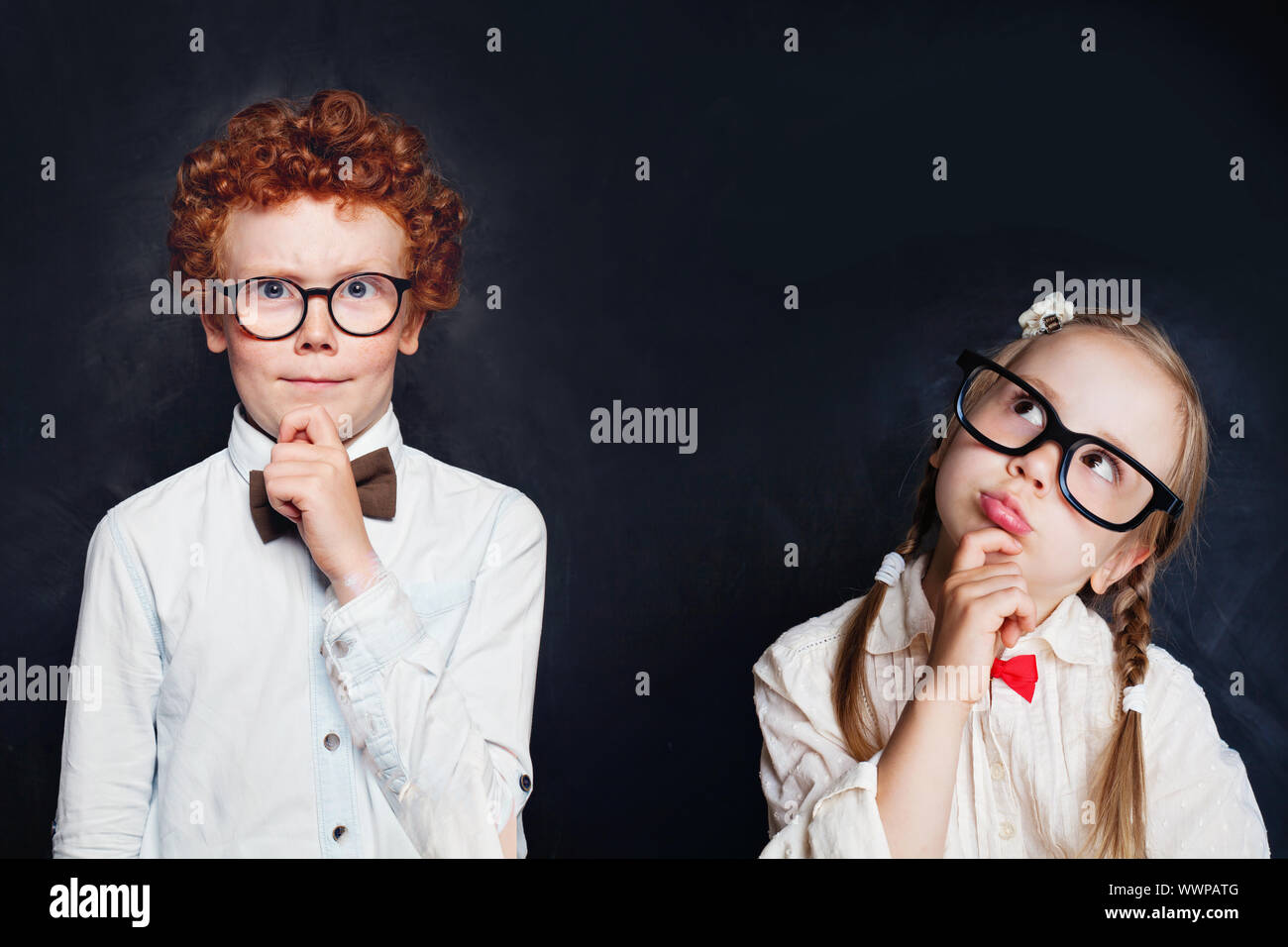 Thinking children boy and girl on blackboard background Stock Photo - Alamy