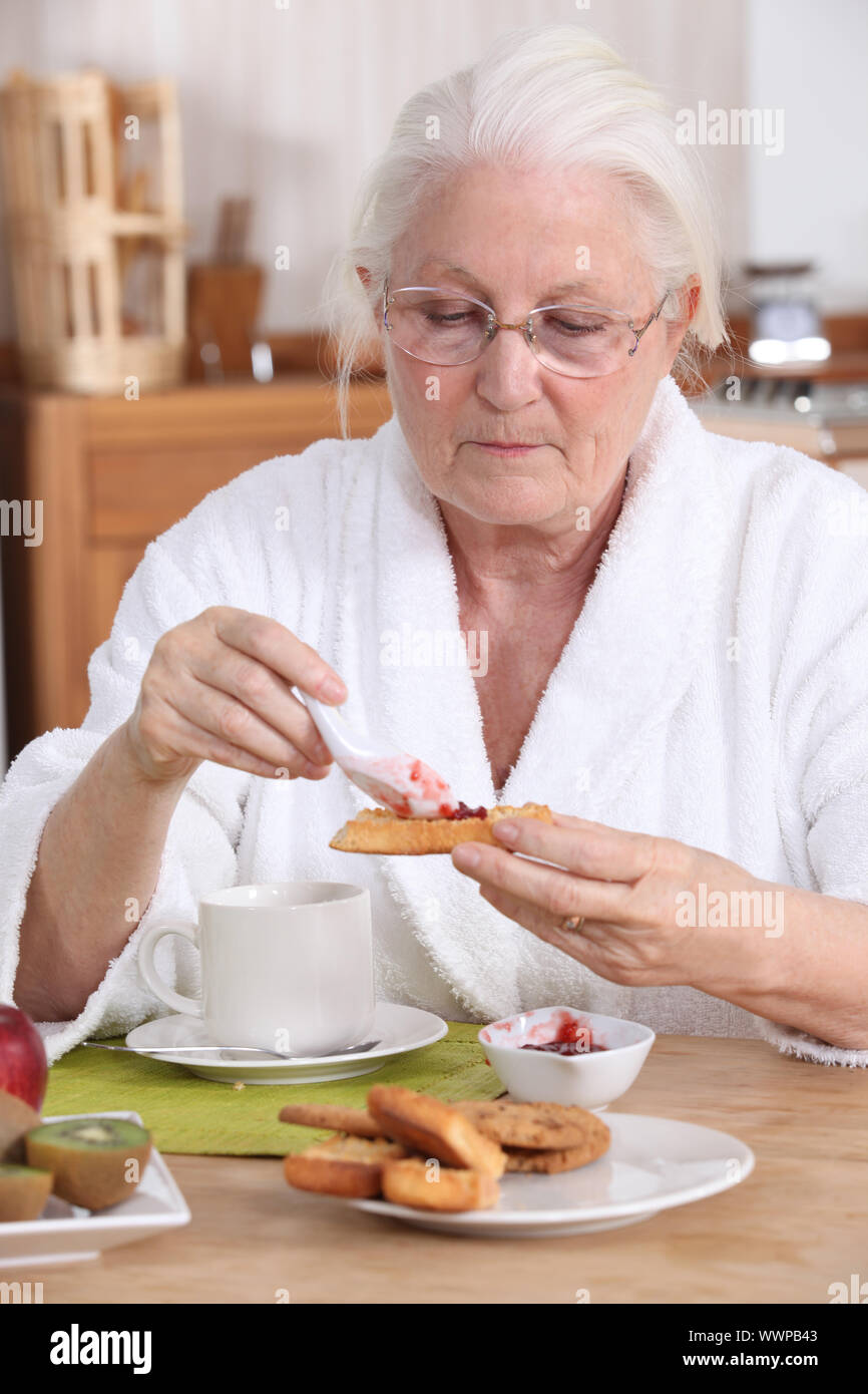 senior woman eating breakfast Stock Photo - Alamy