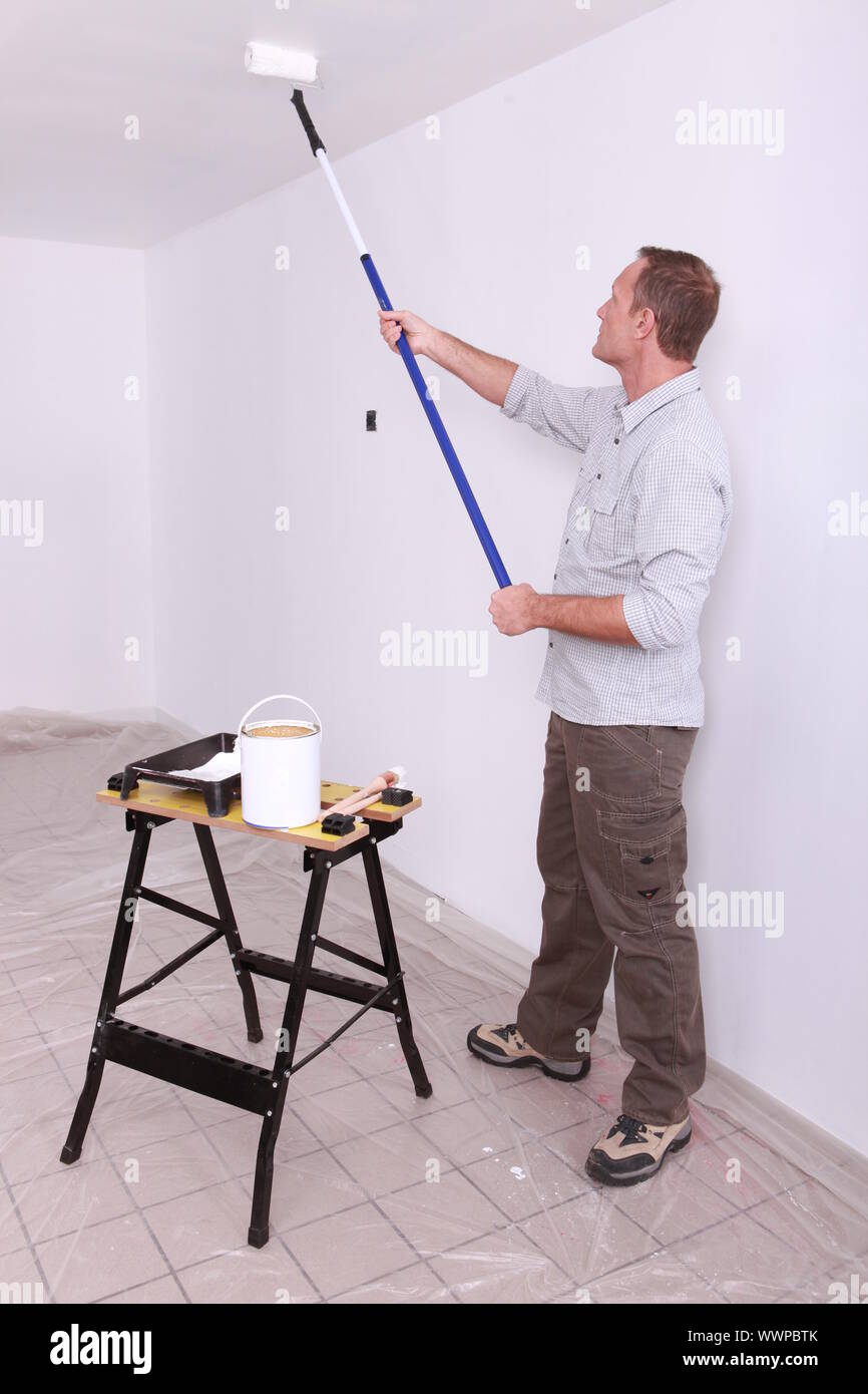 Man painting ceiling with roller Stock Photo - Alamy