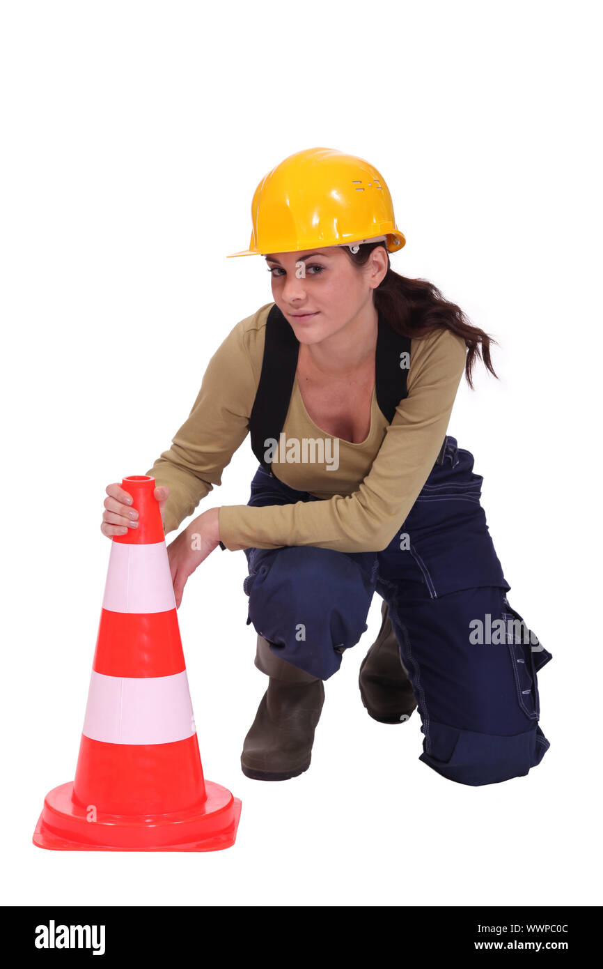 Woman kneeling by traffic cones Stock Photo - Alamy