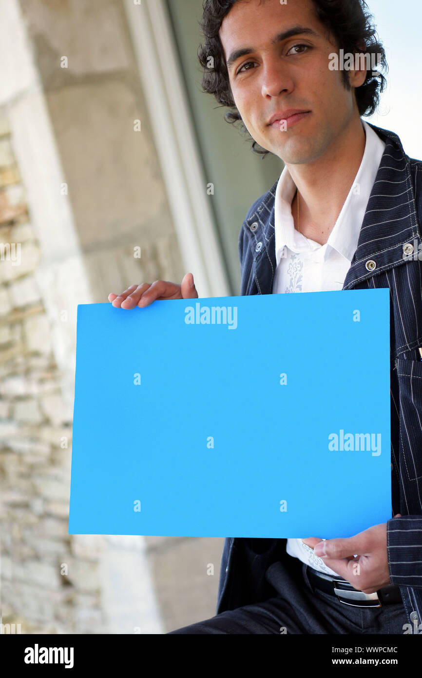 Man stood outside house with blue poster Stock Photo - Alamy