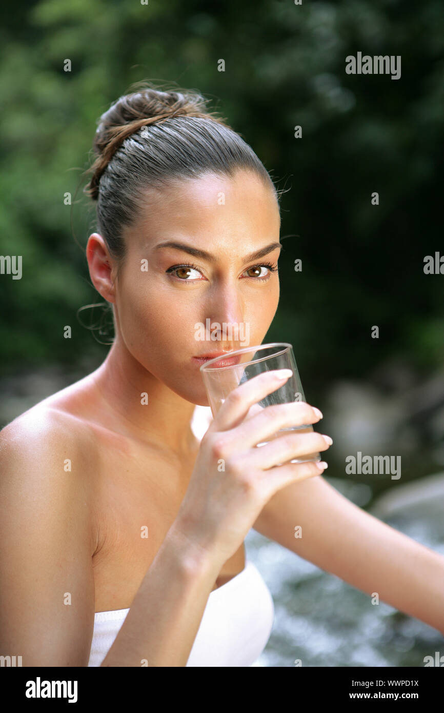Woman drinking glass of water by stream Stock Photo - Alamy