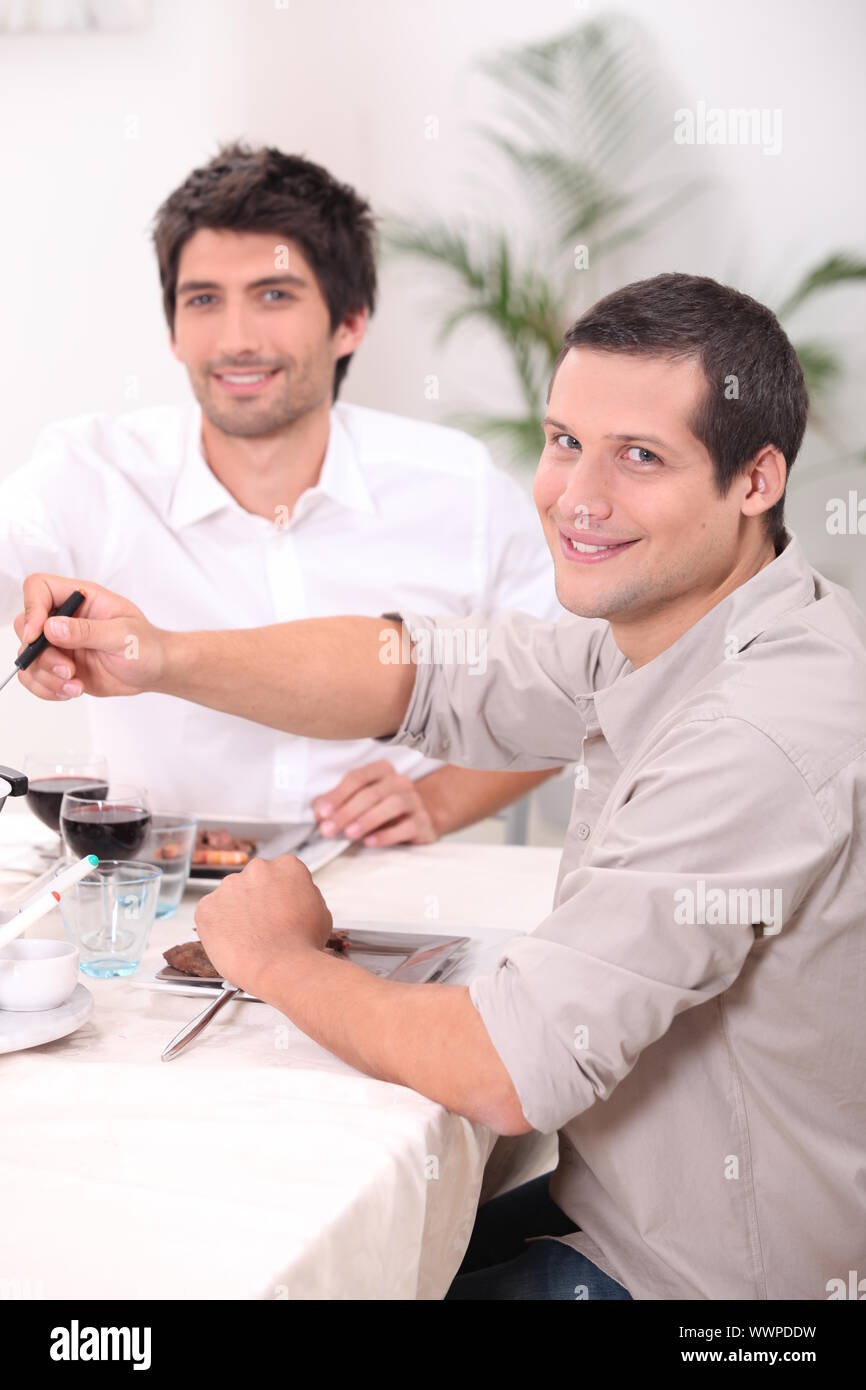 two young men having lunch Stock Photo - Alamy