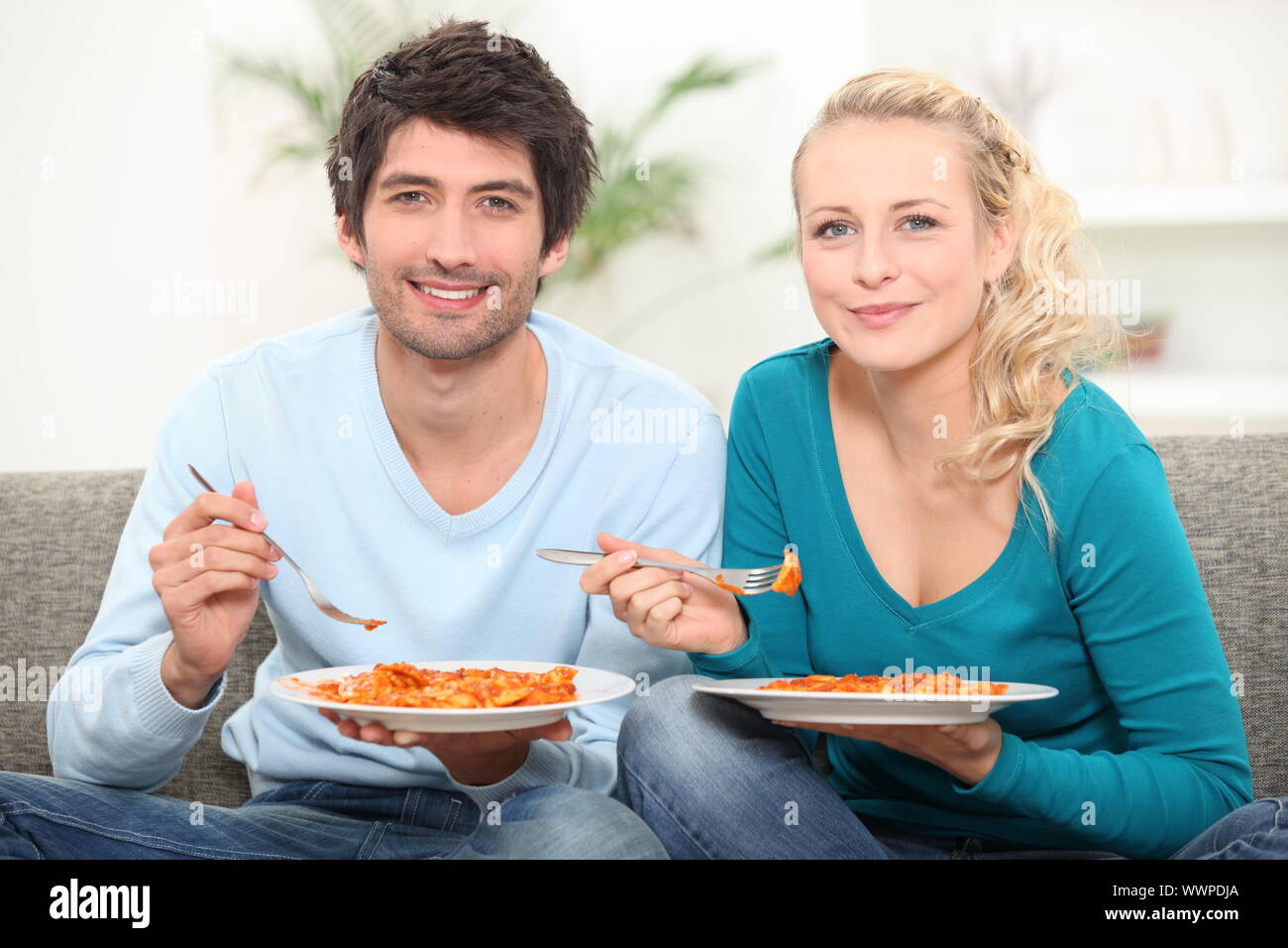 couple having dinner on the couch Stock Photo - Alamy