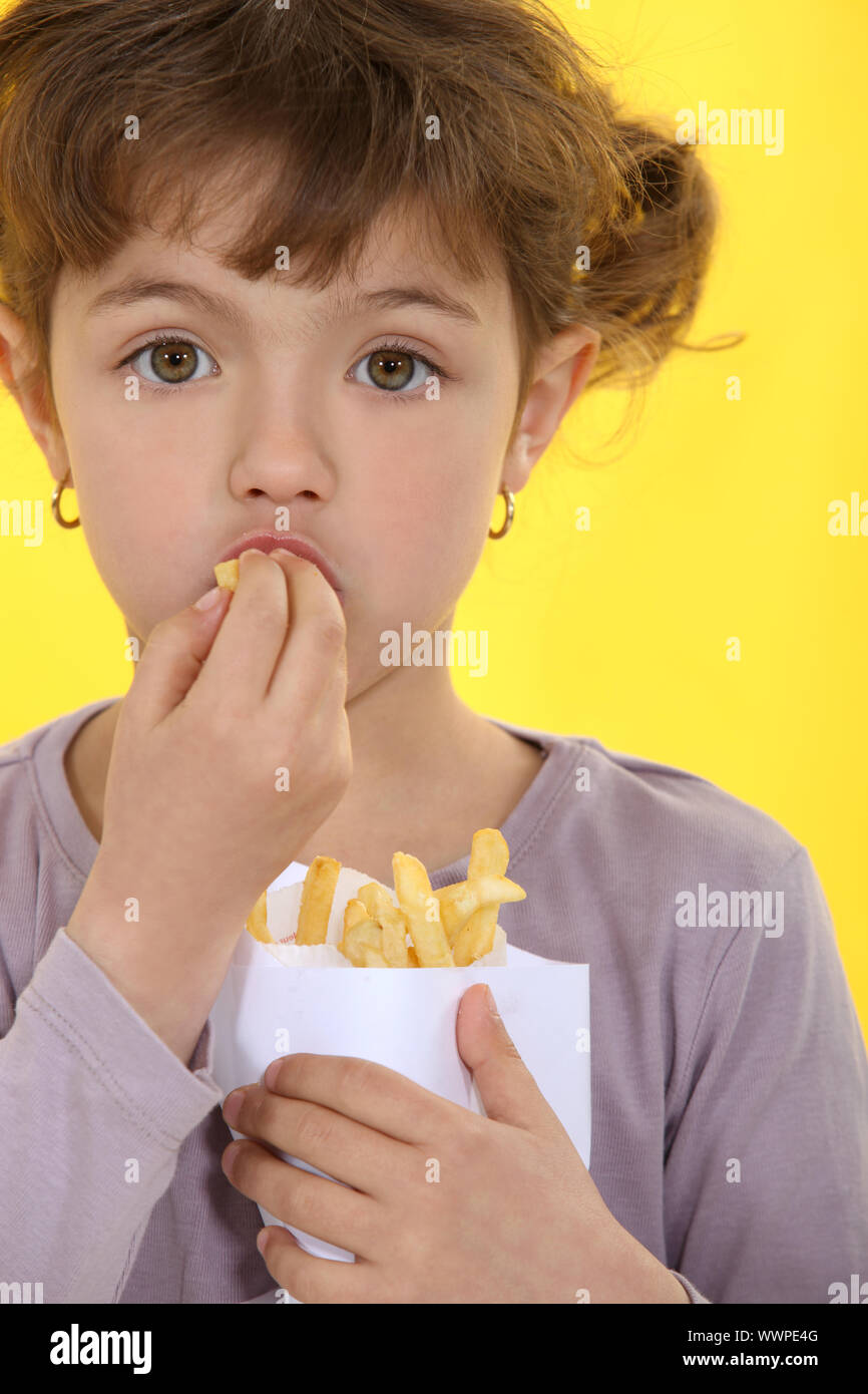 Young girl eating fries Stock Photo - Alamy