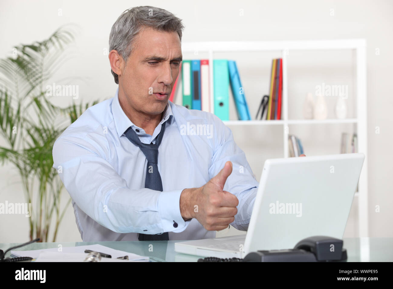 Middle-aged office worker giving thumbs-up Stock Photo - Alamy