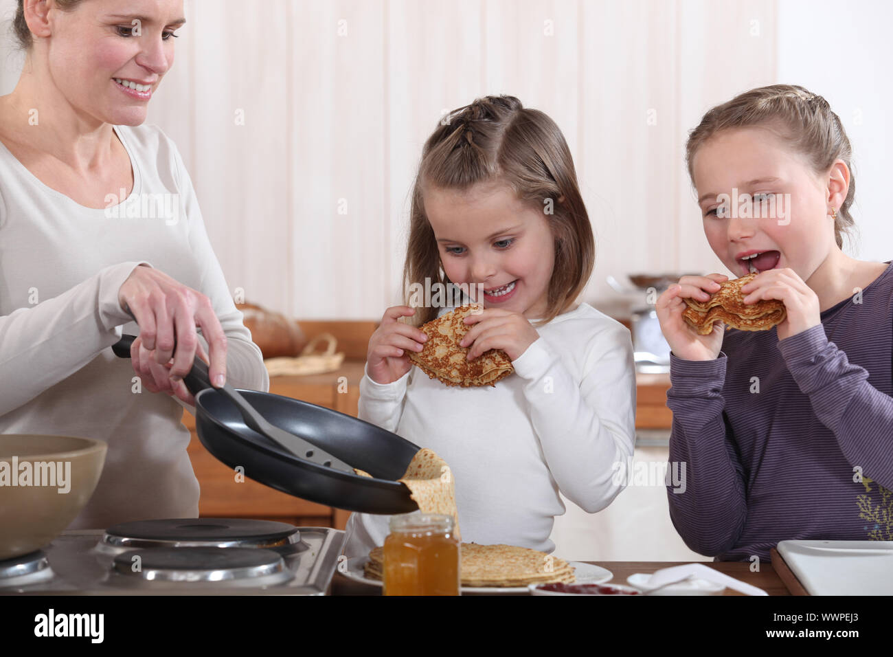 A mother making crepes for her daughters Stock Photo - Alamy