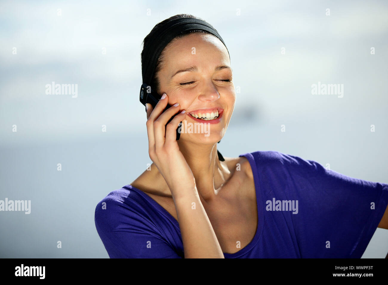 Brunette stood making a call outside Stock Photo - Alamy