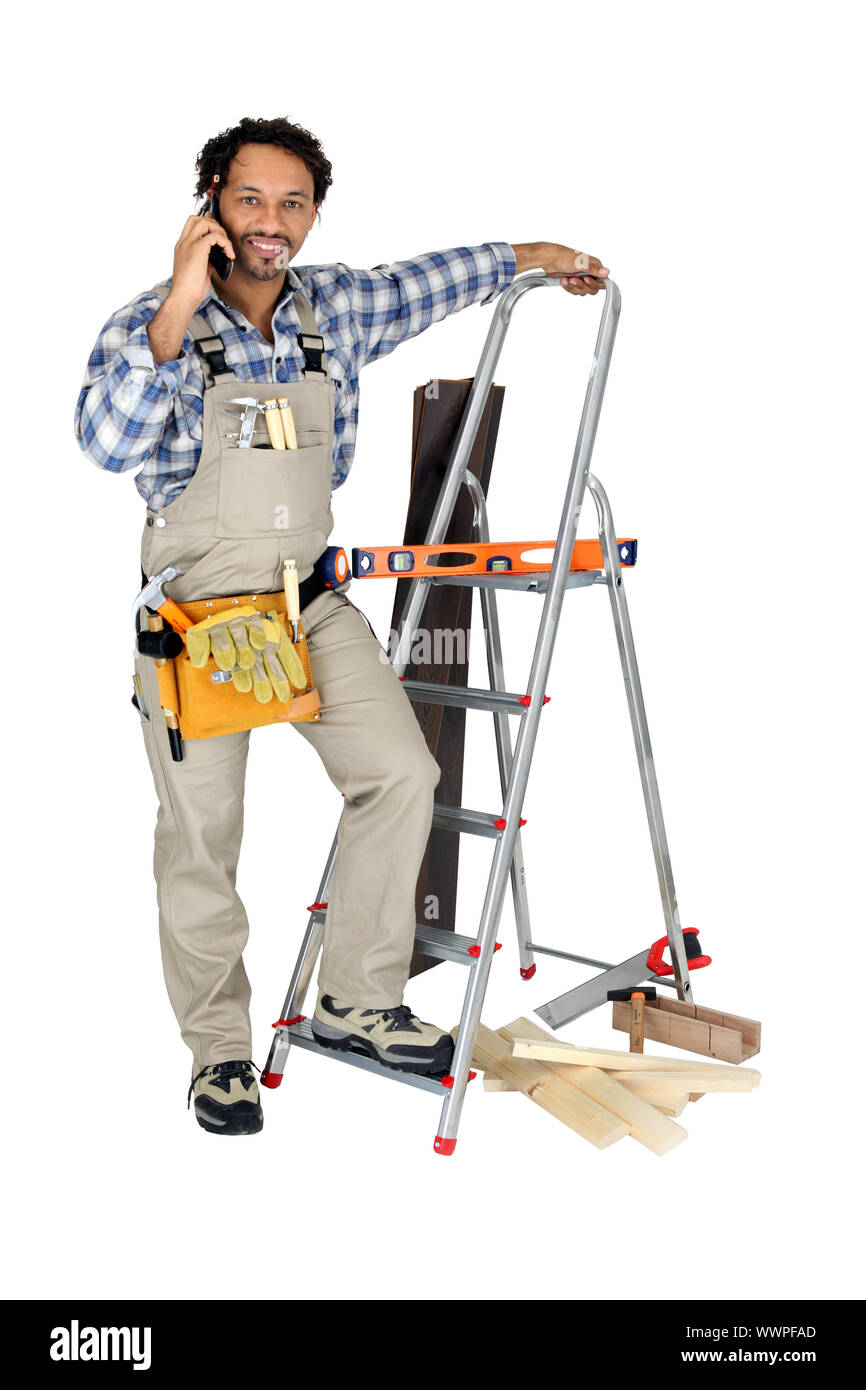 Carpenter speaking on telephone next to ladder Stock Photo - Alamy