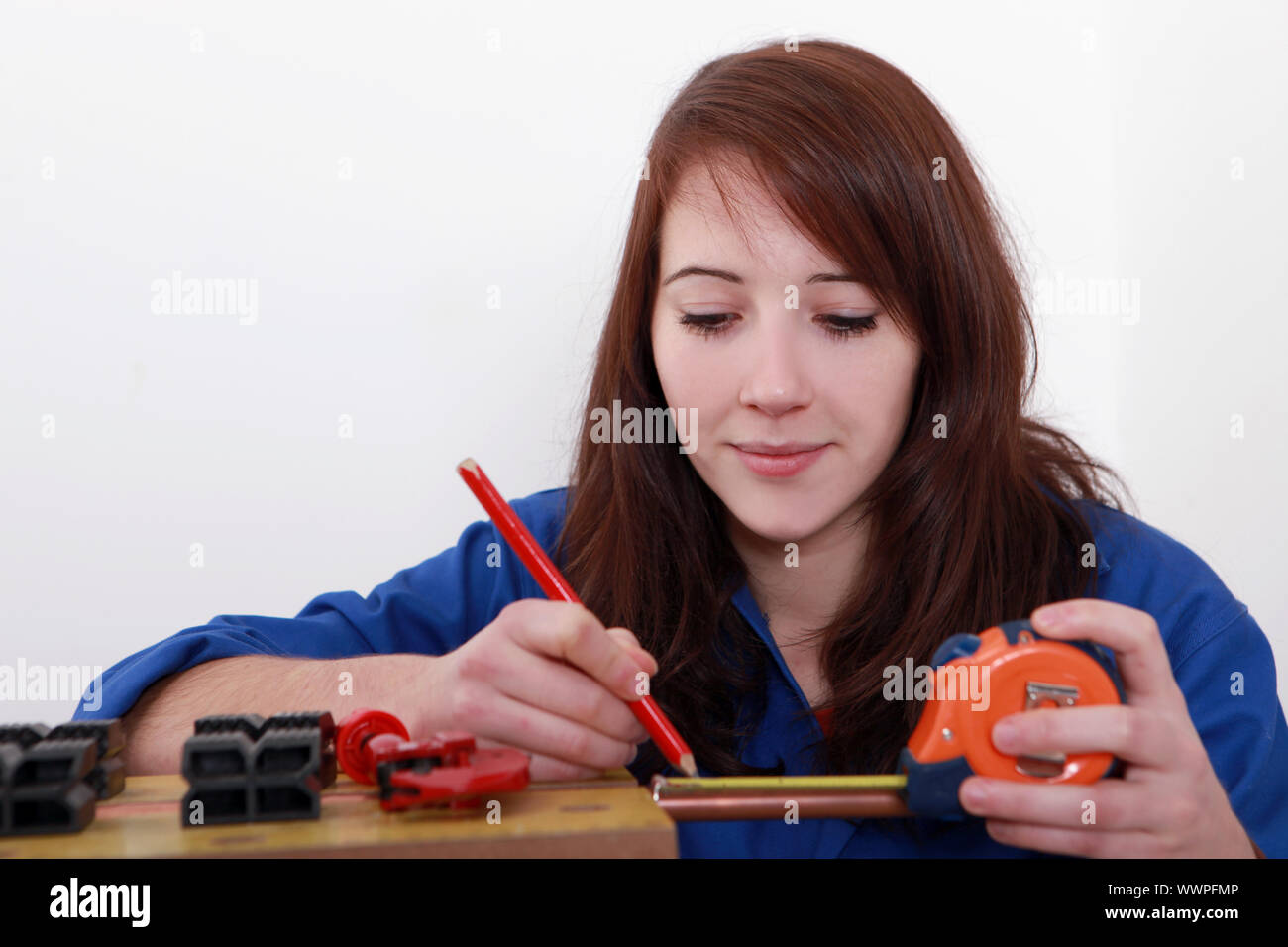 Female plumber marking copper pipe Stock Photo - Alamy
