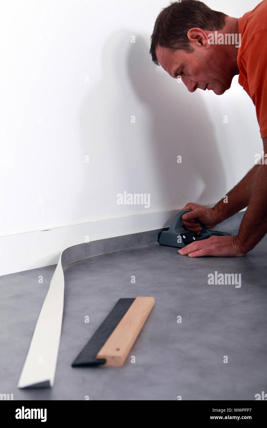 Man smoothing linoleum floor Stock Photo - Alamy