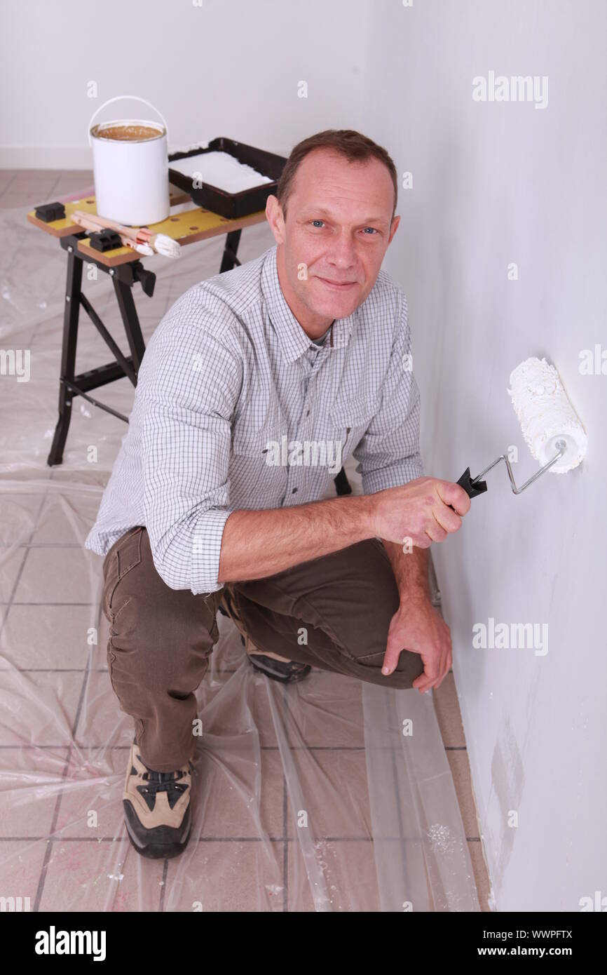 Man painting a wall white Stock Photo - Alamy