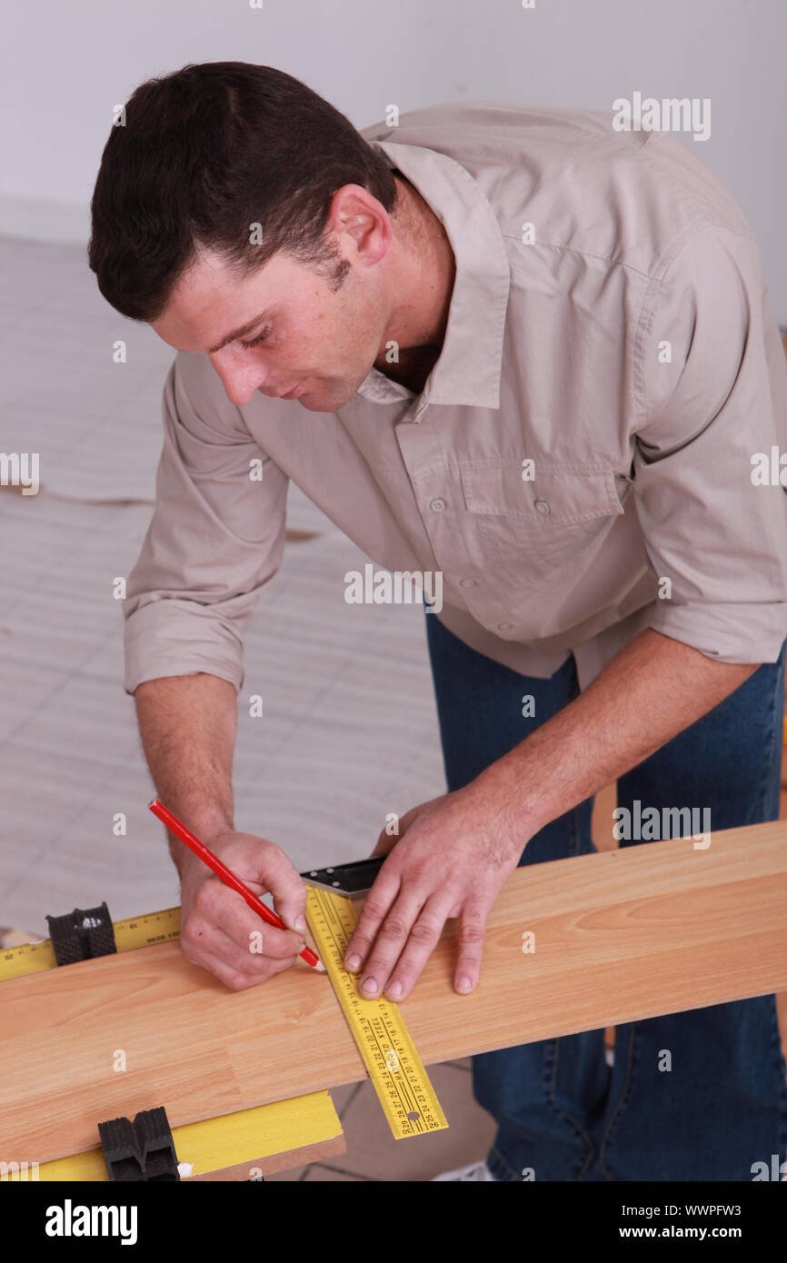 Man measuring wooden plank Stock Photo - Alamy