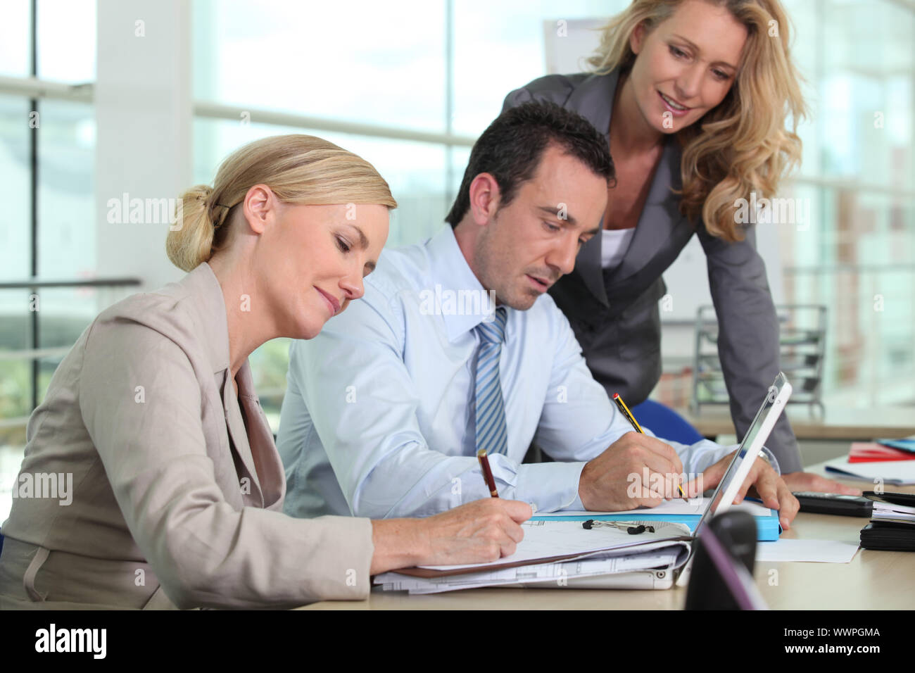 Three colleagues working together Stock Photo - Alamy