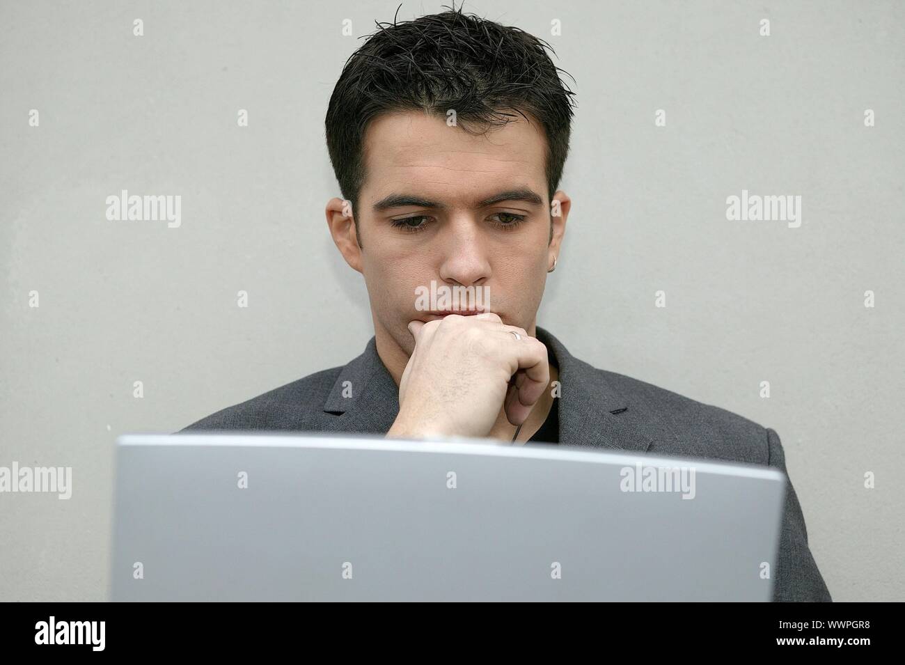 Serious man looking at his laptop Stock Photo - Alamy