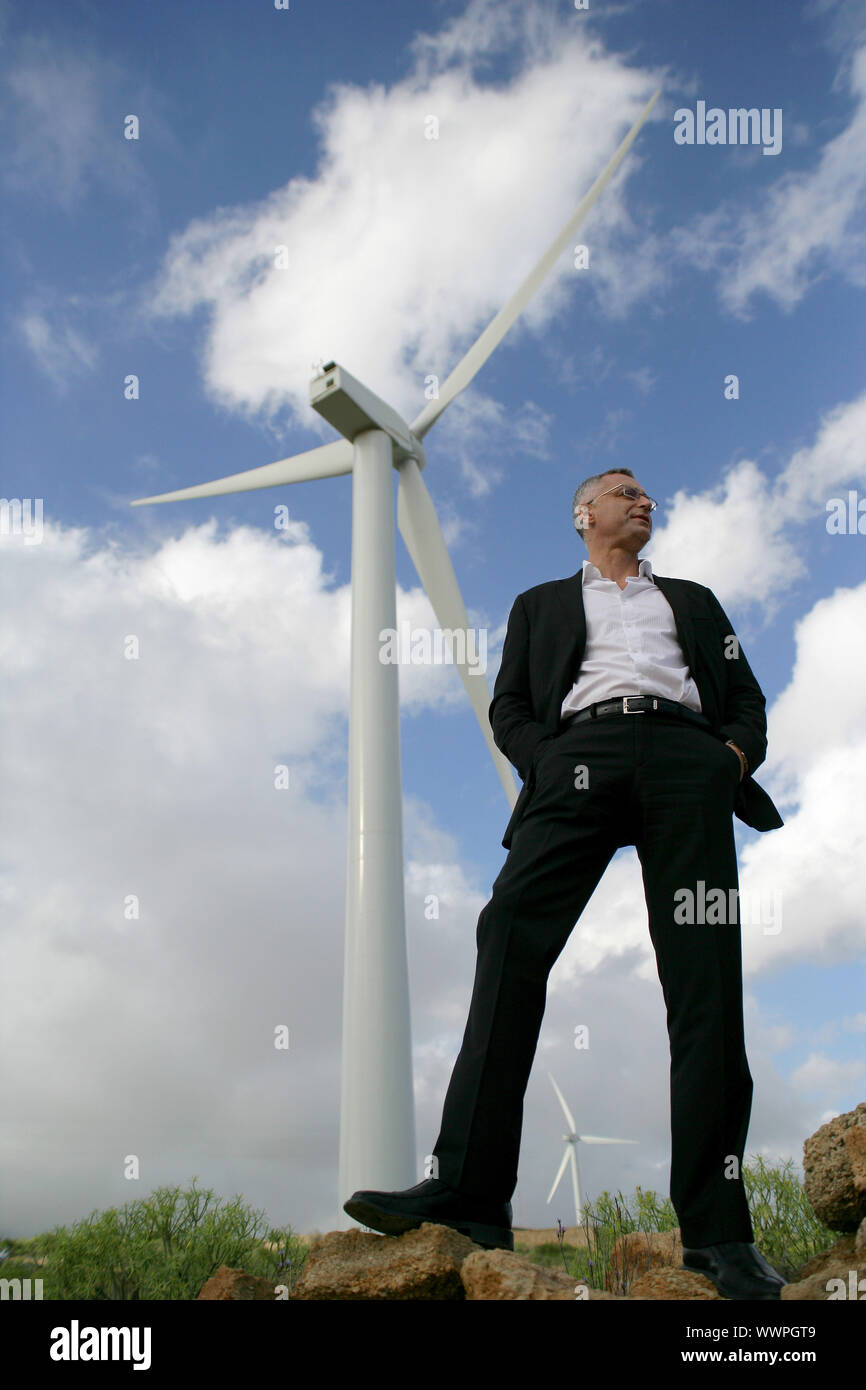 Man standing next to a wind turbine Stock Photo - Alamy