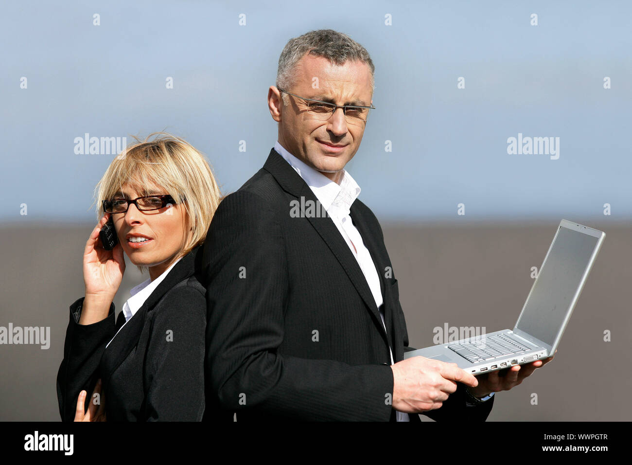 Business partners stood back to back Stock Photo - Alamy