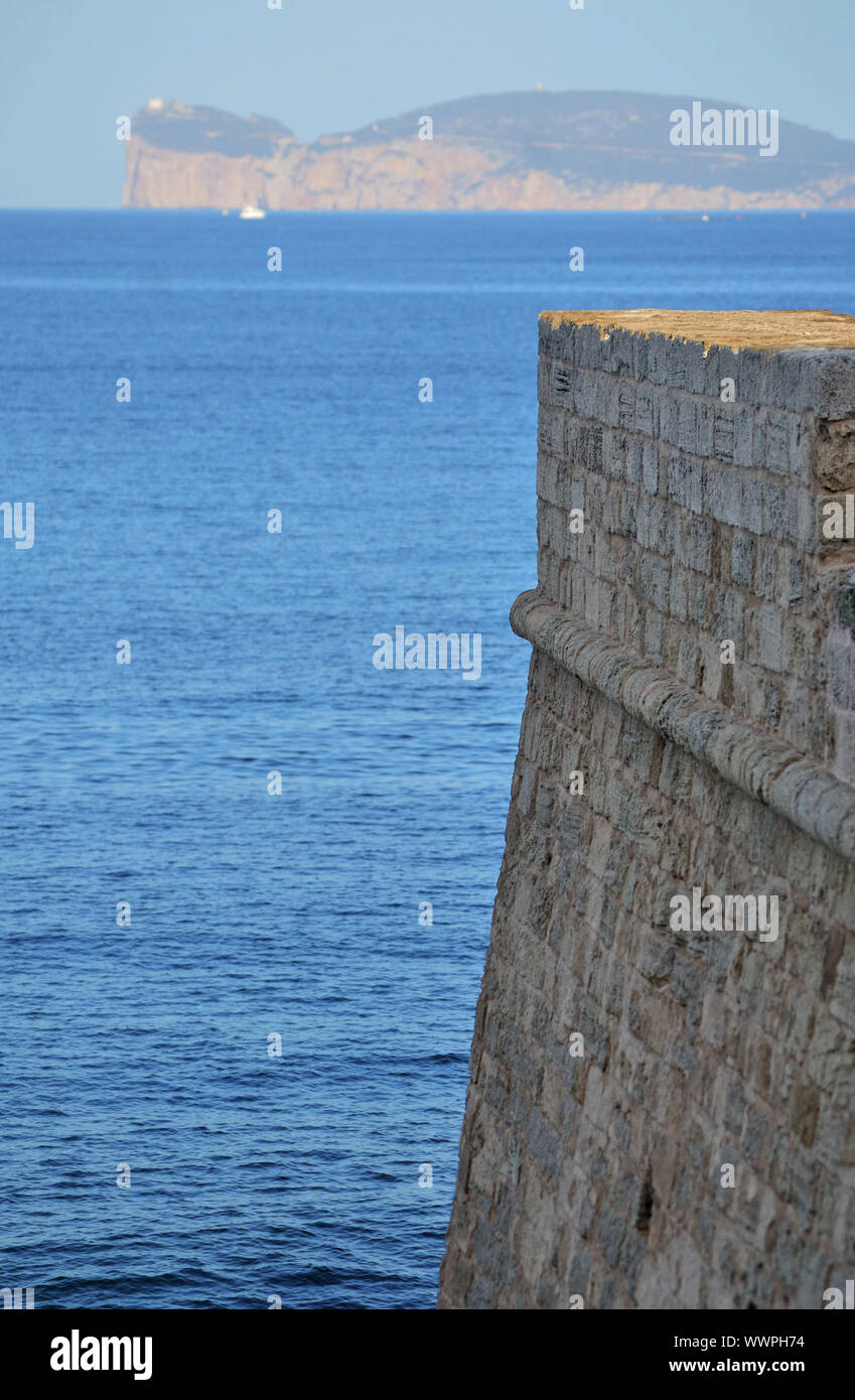 a high bastion of the ancient city walls along the sea with Capo Caccia ...