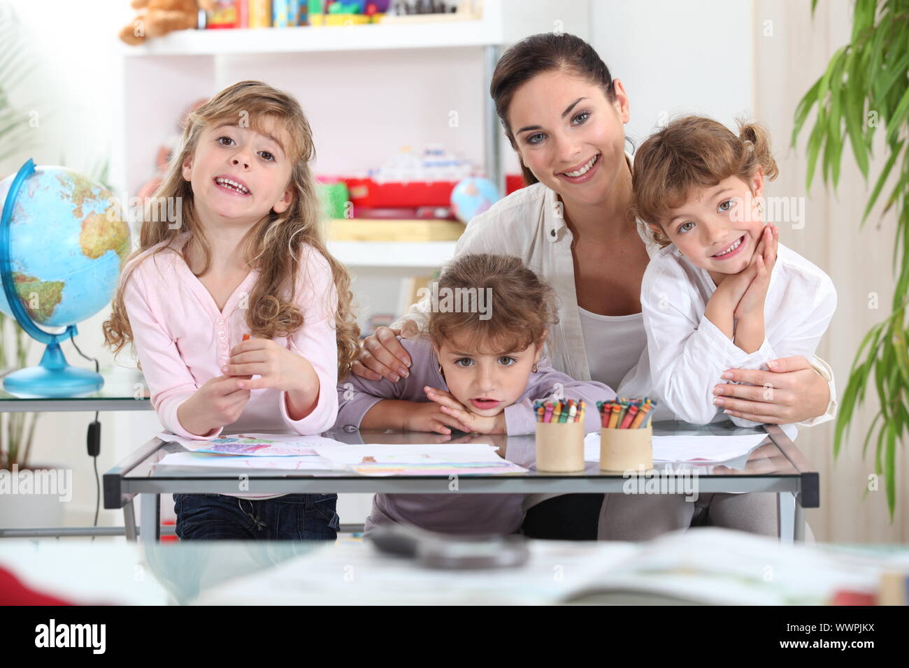Mother drawing with three daughters Stock Photo - Alamy
