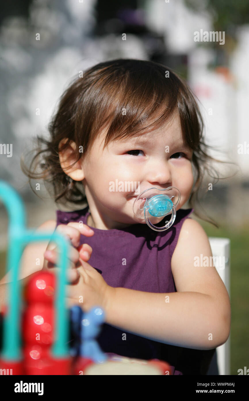 Little girl with dummy at at the playground Stock Photo - Alamy
