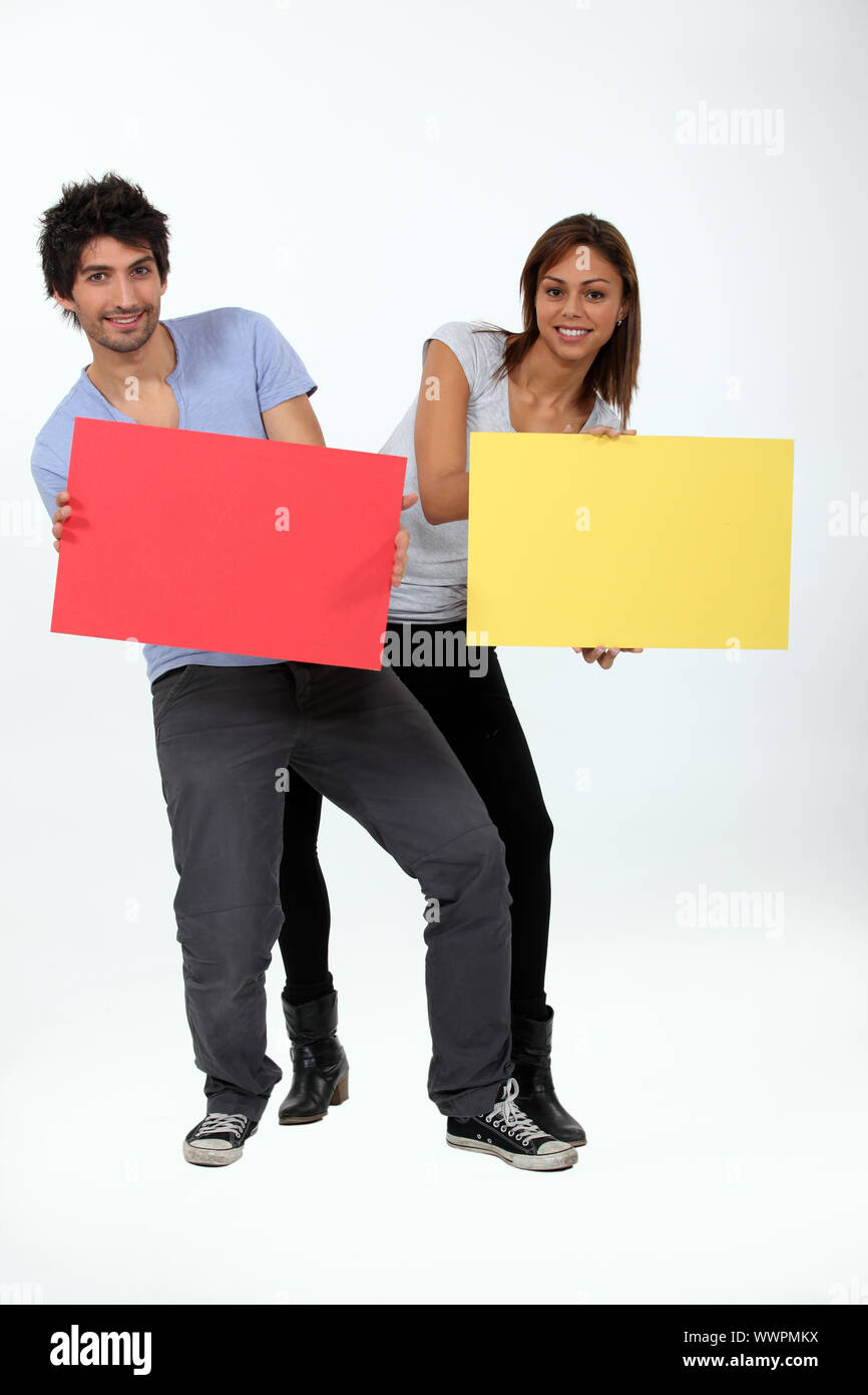 a young man and a young woman calling attention by showing panels Stock ...