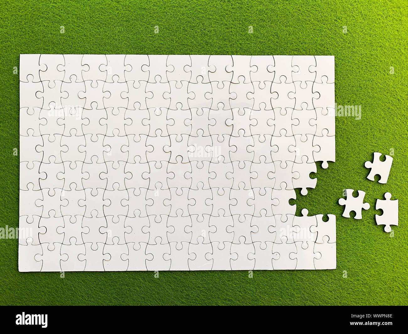 Top view, white puzzle on green background Stock Photo - Alamy