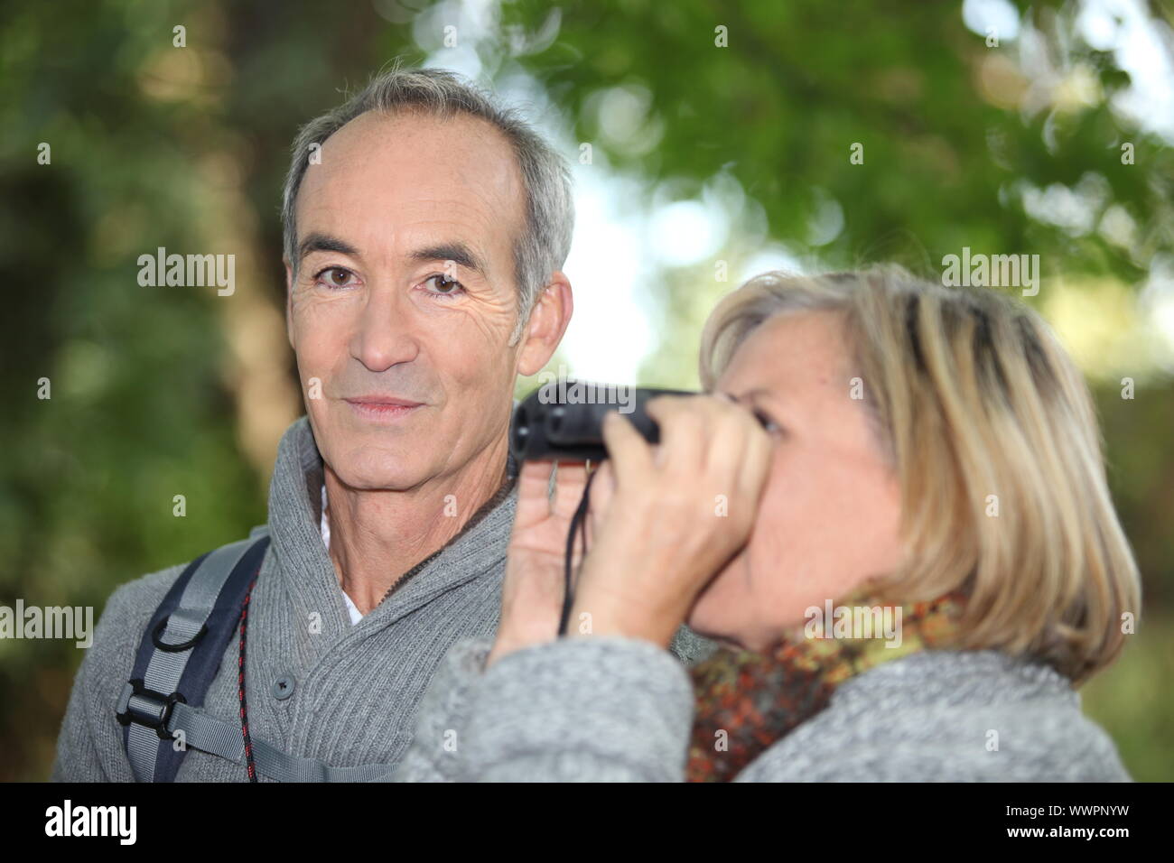 Husband and wife birdwatching in the forest Stock Photo - Alamy