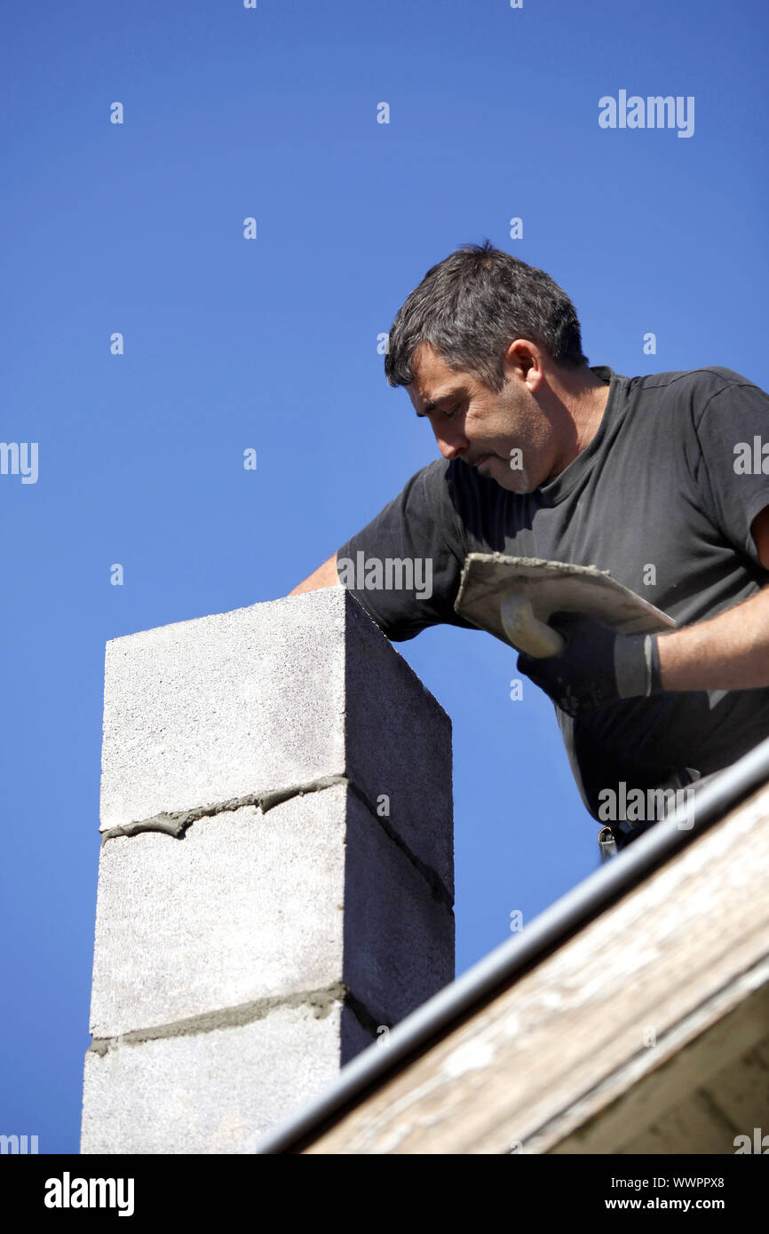 Mason building chimney Stock Photo - Alamy
