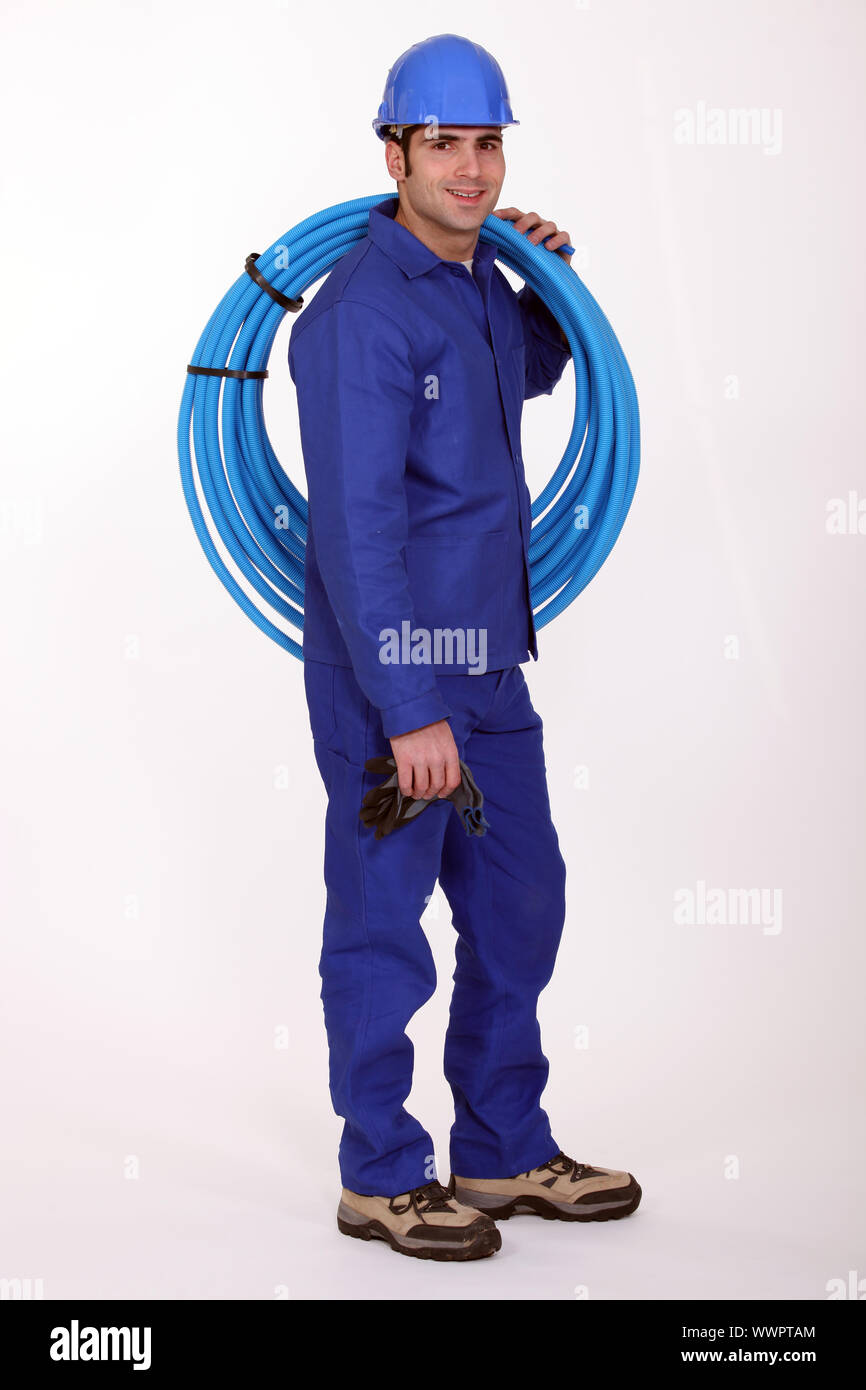 Plumber with a reel of blue pipe Stock Photo - Alamy