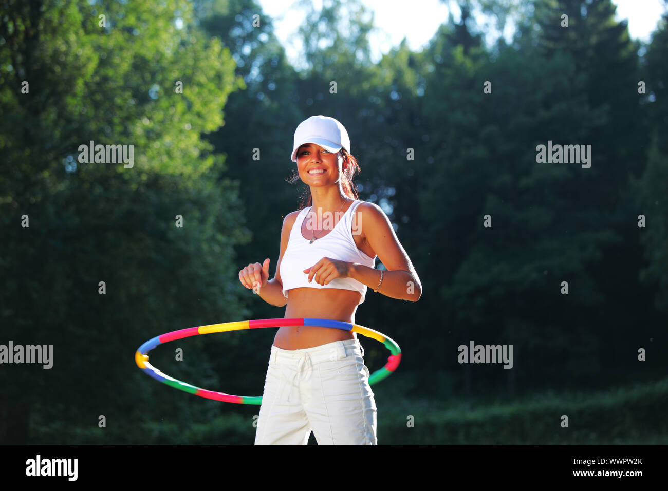 woman rotates hula hoop on nature background Stock Photo - Alamy