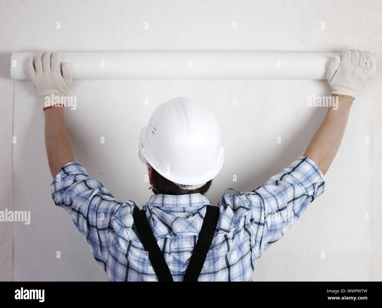 worker attaching wallpaper to wall Stock Photo - Alamy