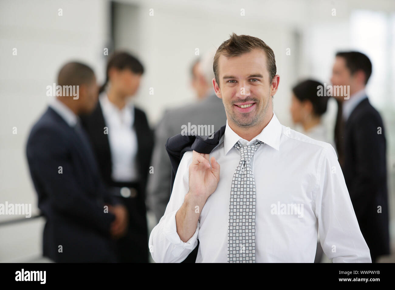Business stood in front of colleagues with jacket over shoulder Stock ...