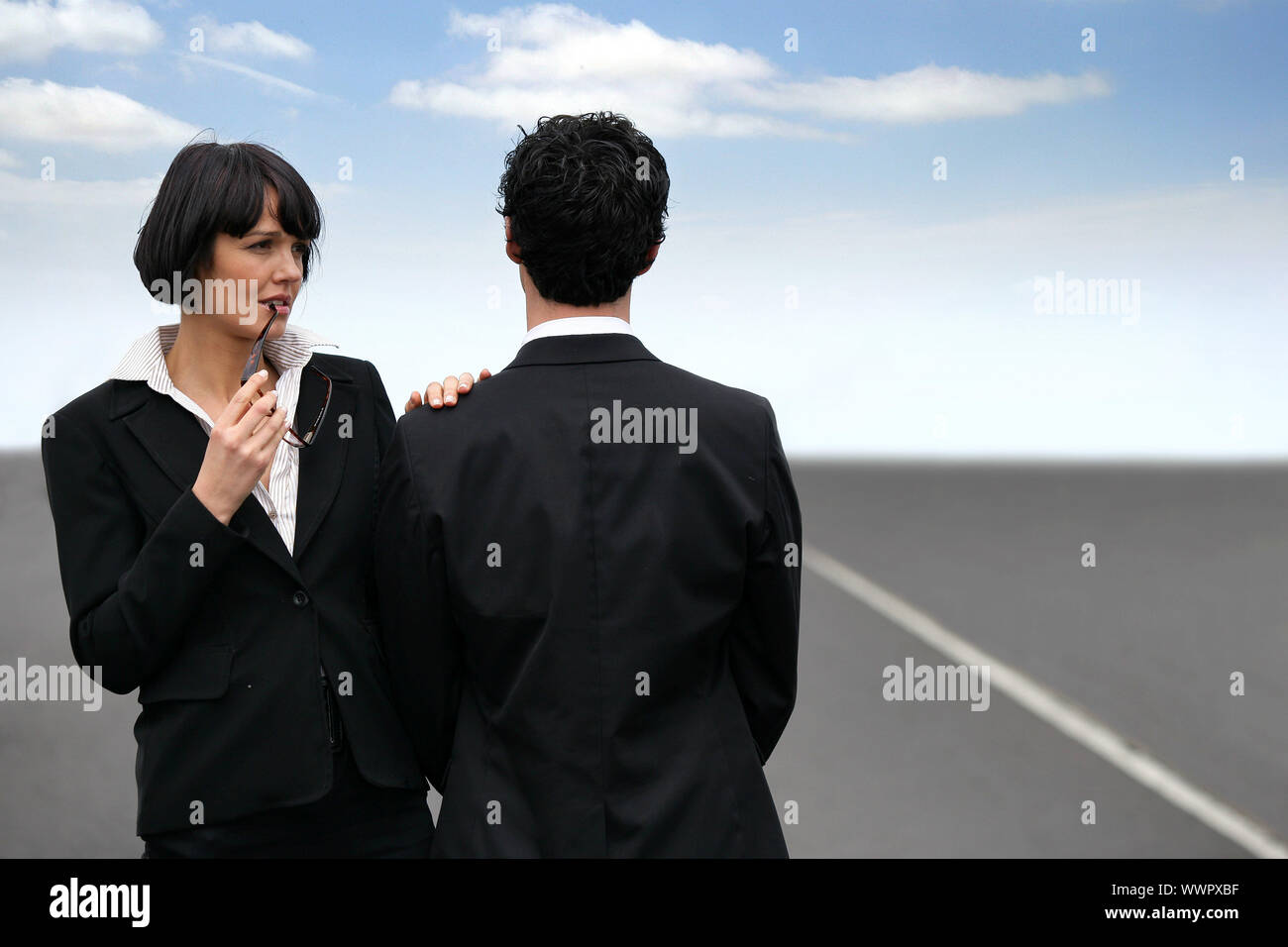 Conceptual shot of a business couple standing facing different ...