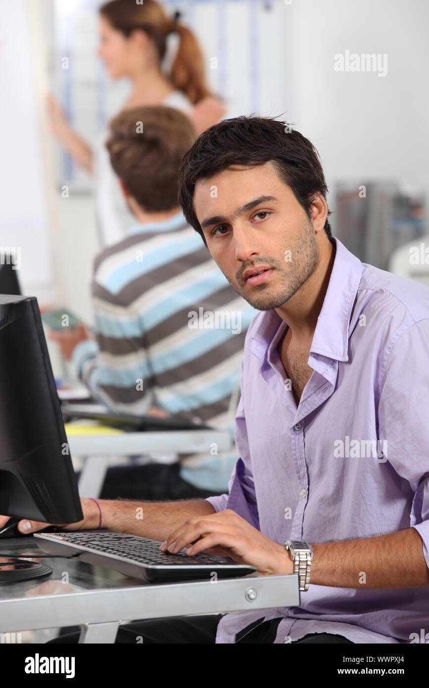 Young man typing at a computer keyboard Stock Photo - Alamy