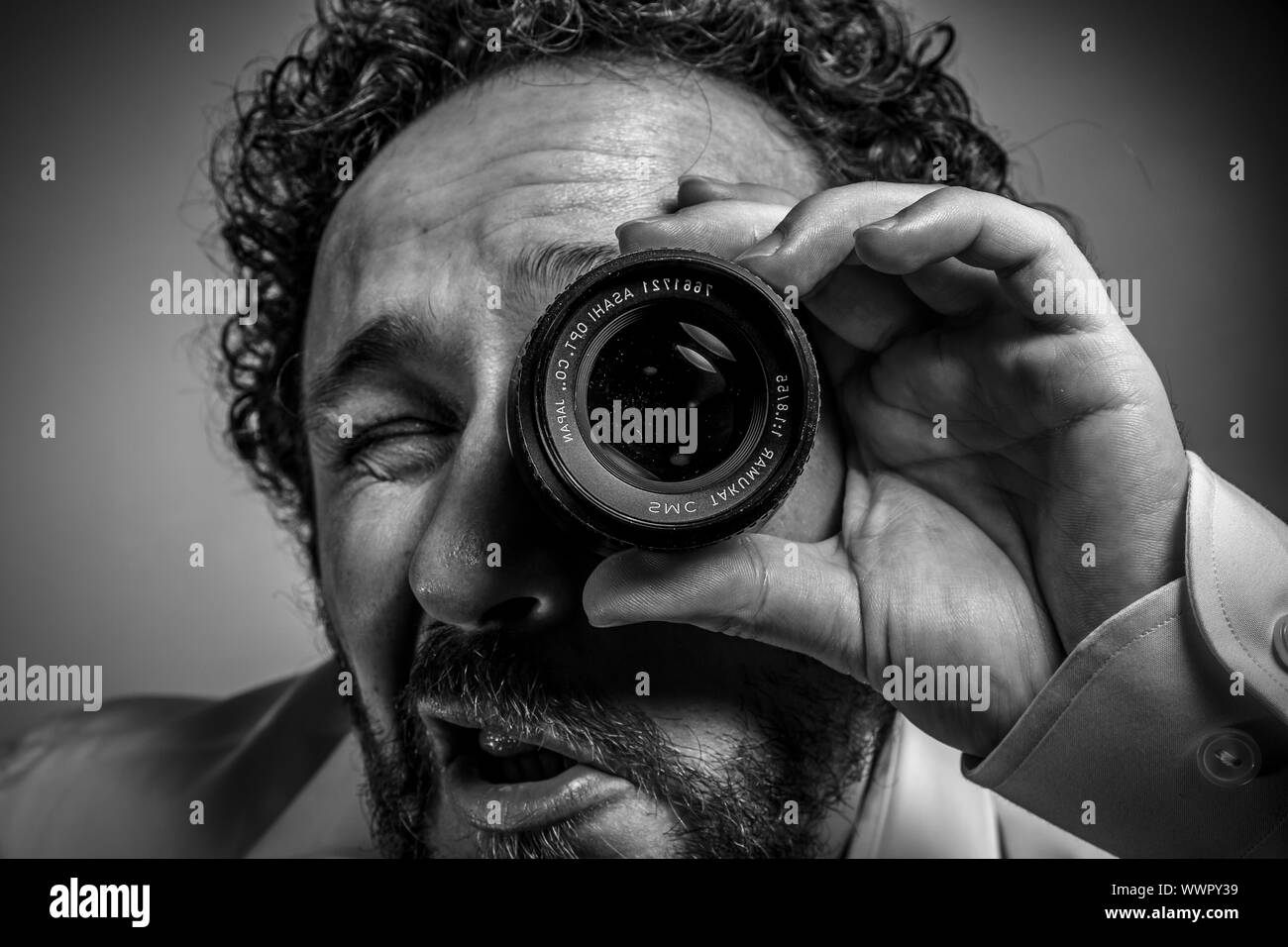 photographer with lens, man with intense expression, white shirt Stock ...