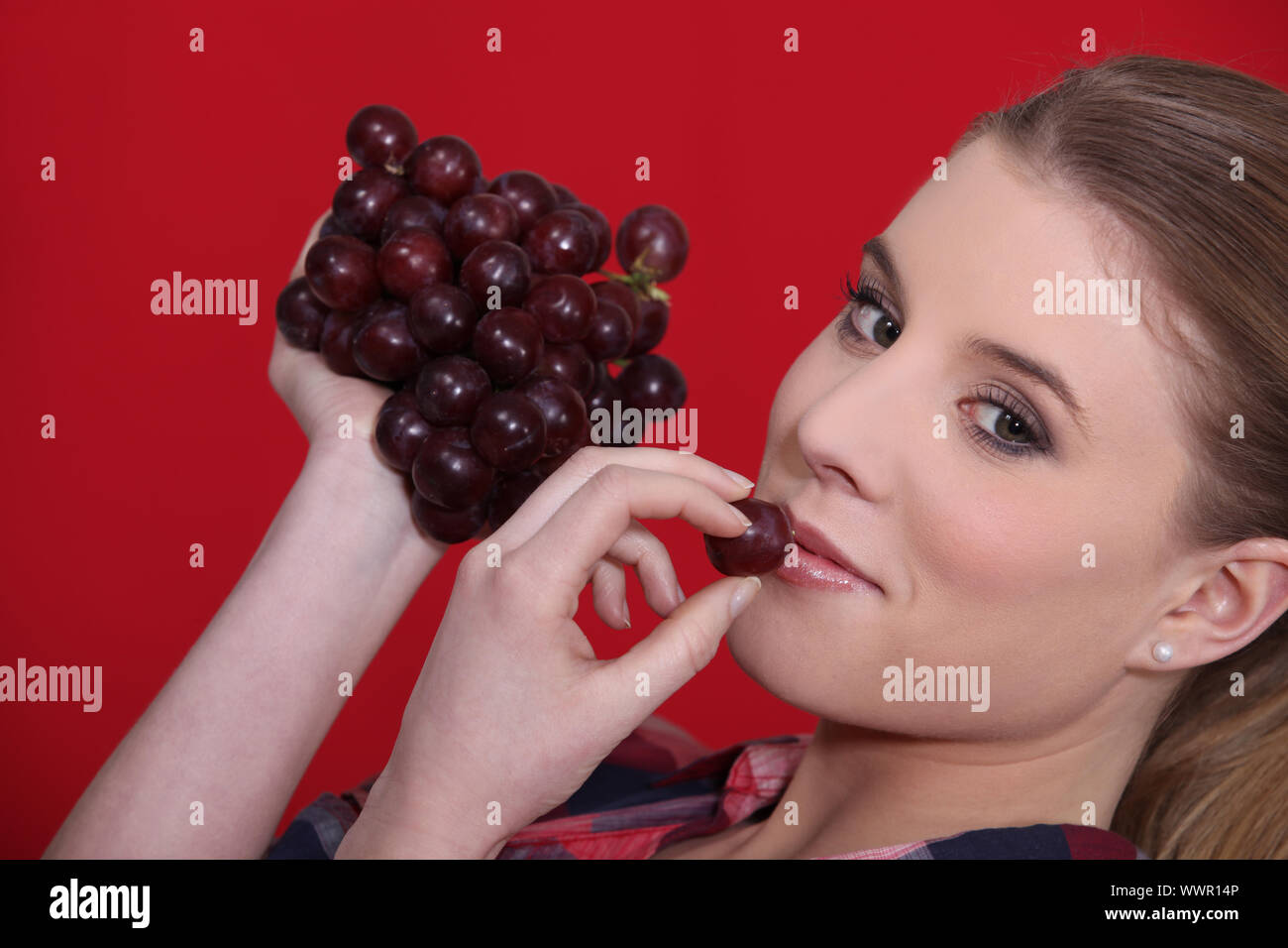 Woman eating grapes Stock Photo - Alamy