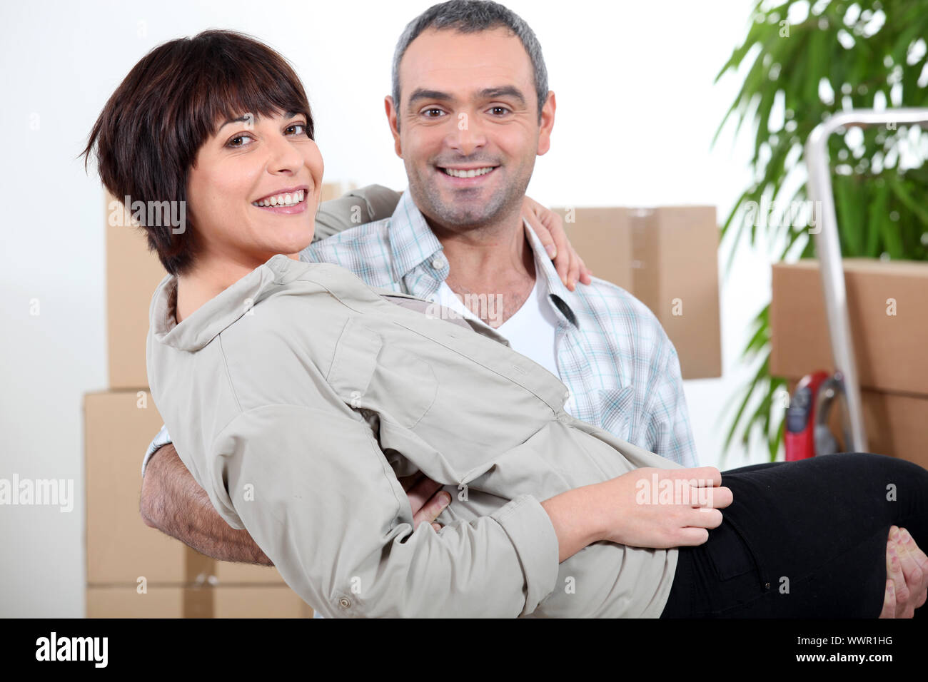 Man carrying his wife over the threshold Stock Photo - Alamy