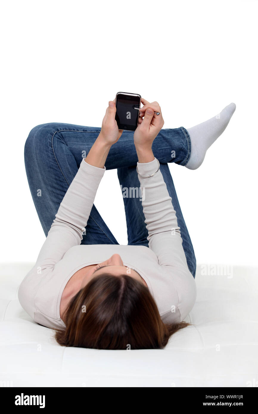 A woman lying and checking her phone Stock Photo - Alamy